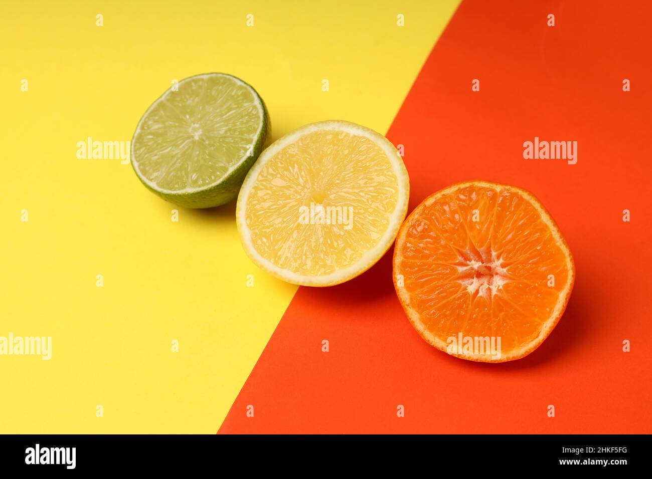 Halves of citrus fruits on two tone background Stock Photo - Alamy