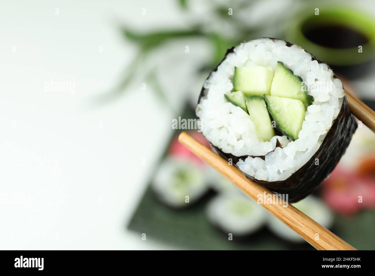 Chopsticks with maki, closeup and space for text Stock Photo - Alamy