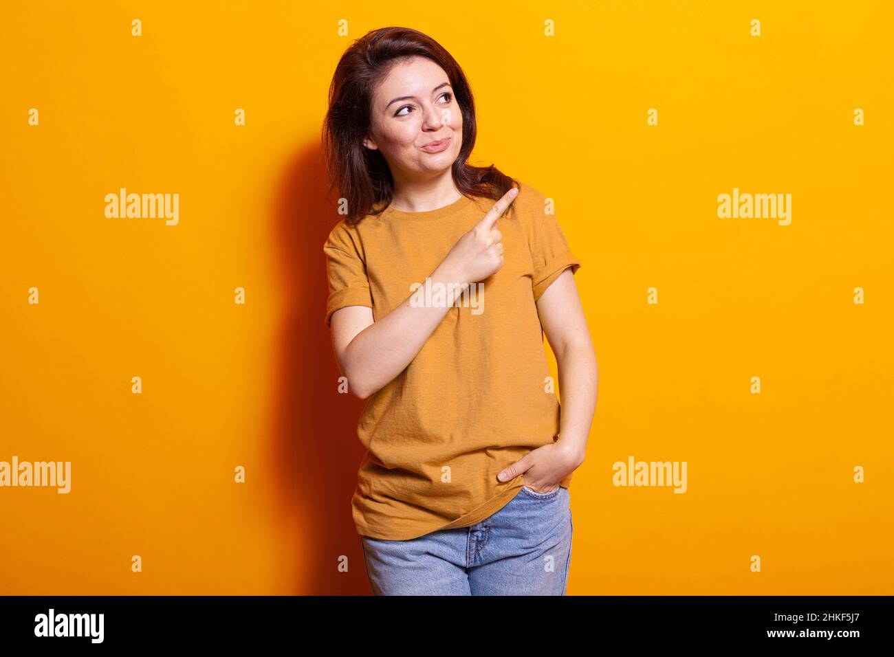 Positive adult using index finger to point at right side of studio ...
