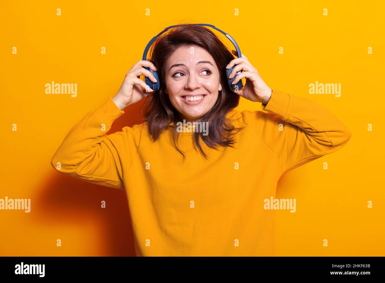Caucasian woman feeling excited and listening to music on headphones ...