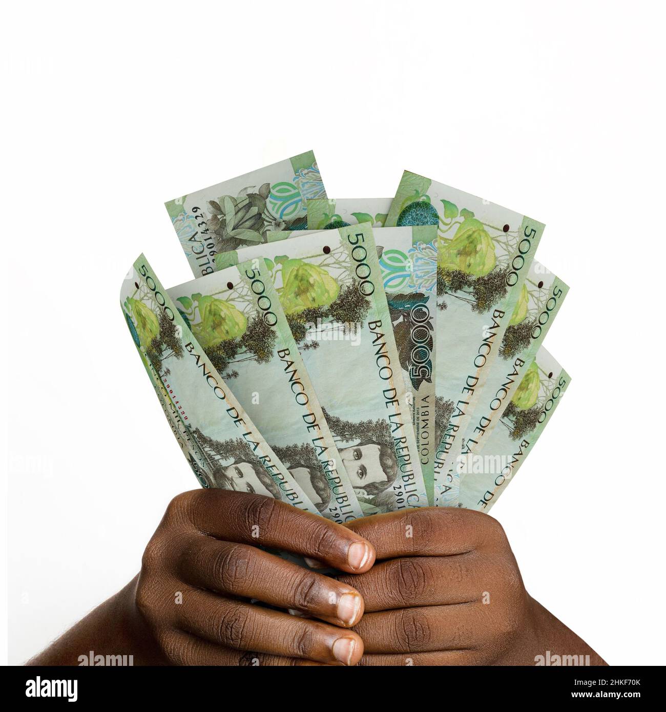 Black hands holding 3D rendered 5000 Colombian peso notes. closeup of ...