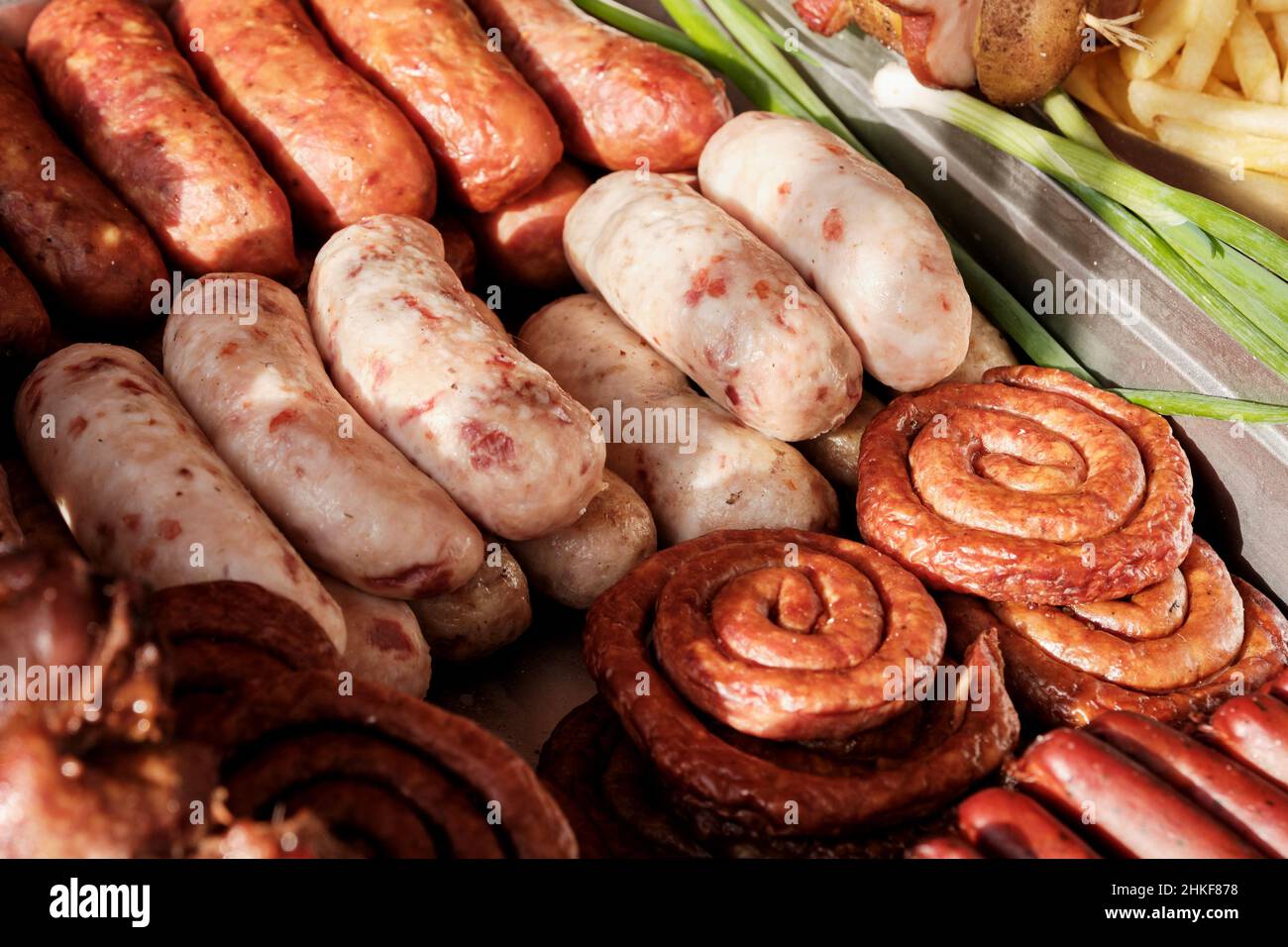 Meat thin sausages, twisted in a spiral, are located next to other ...
