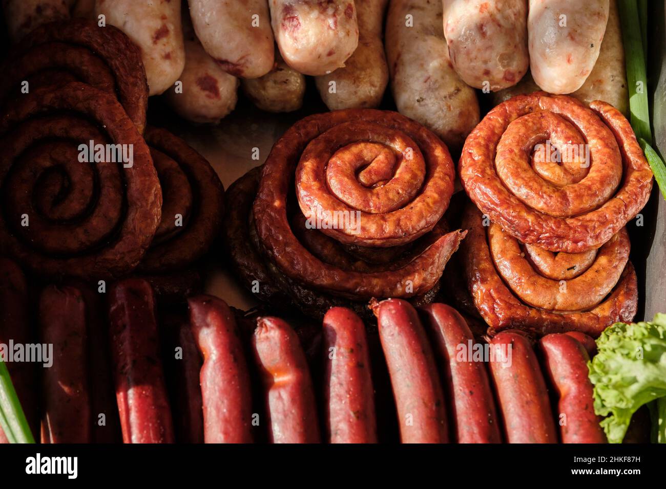 Meat thin sausages, twisted in a spiral, are located next to other ...