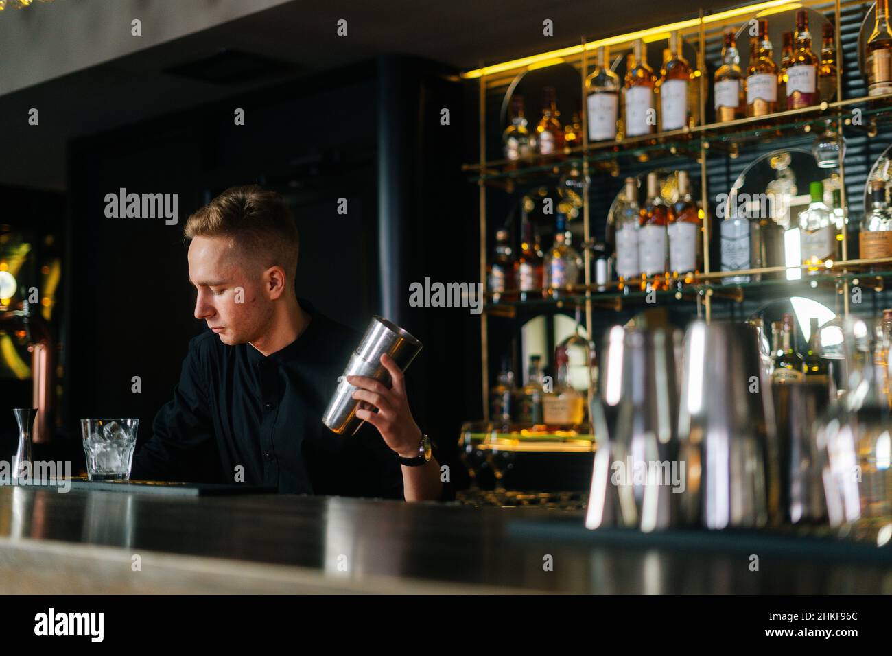 Side view of professional bartender preparing refreshing alcoholic ...
