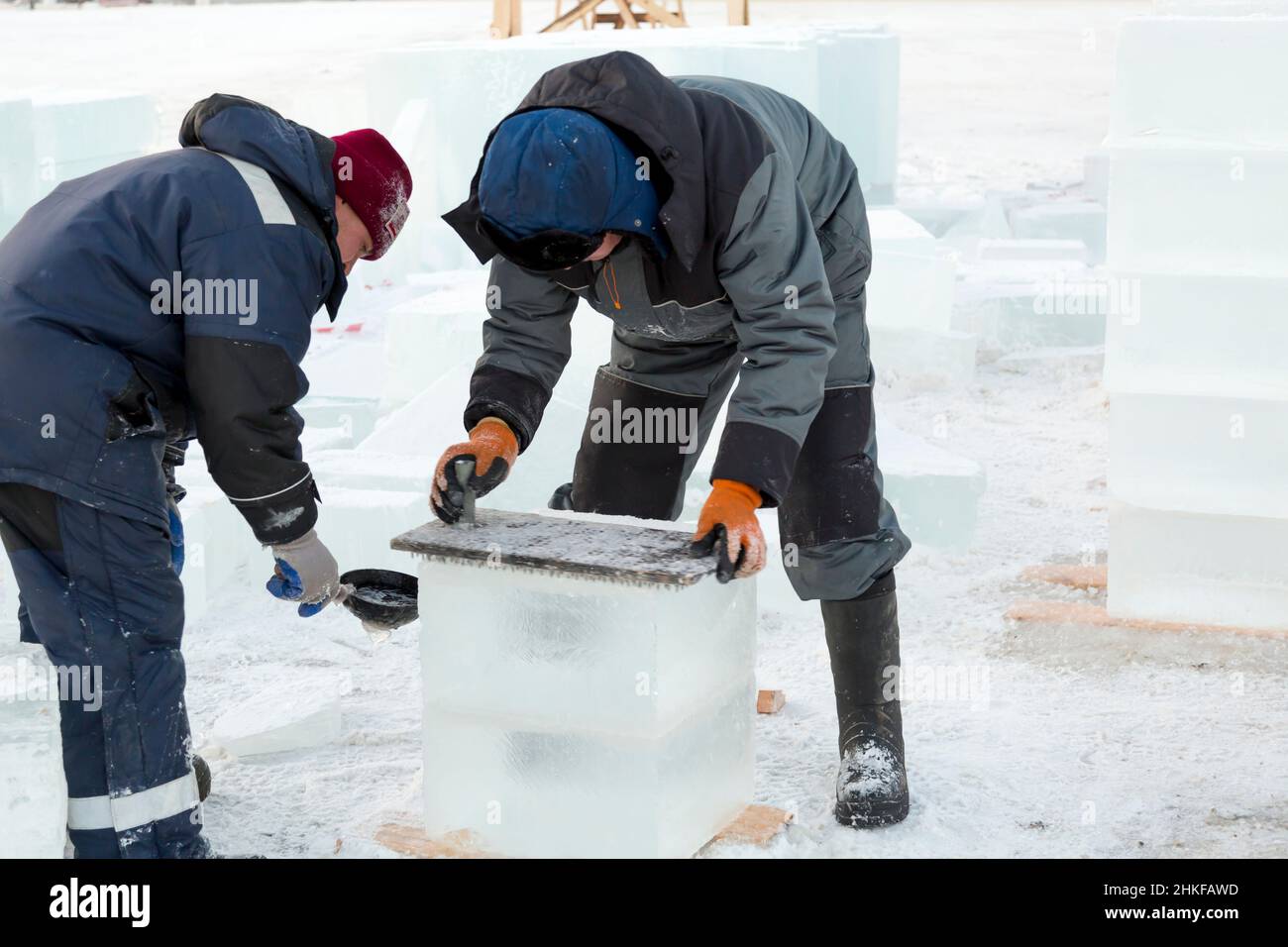 The builder cleans the ice panel with a wire brush from snow Stock ...