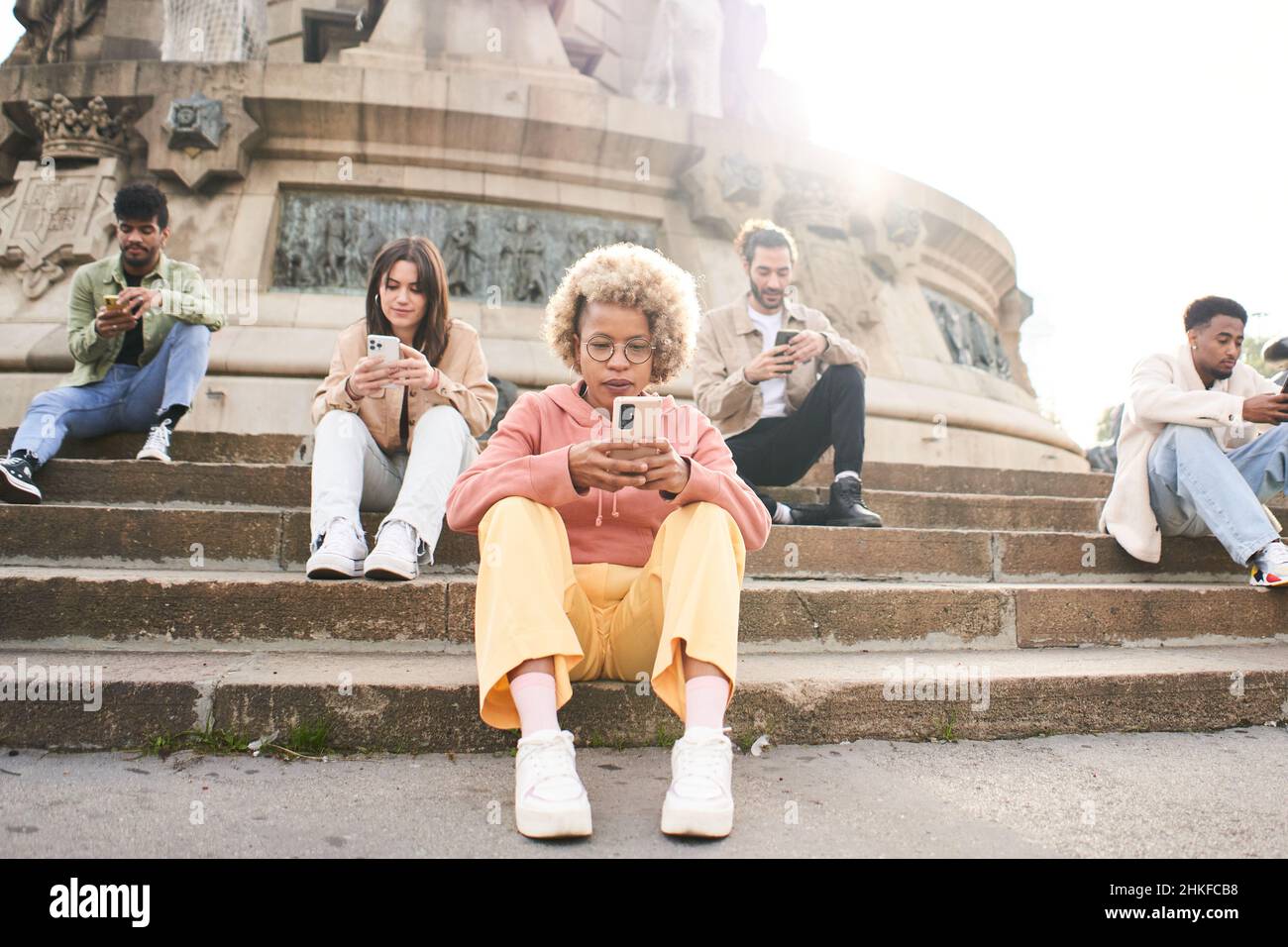 Group of individualistic people using phone outdoors with serious face ...