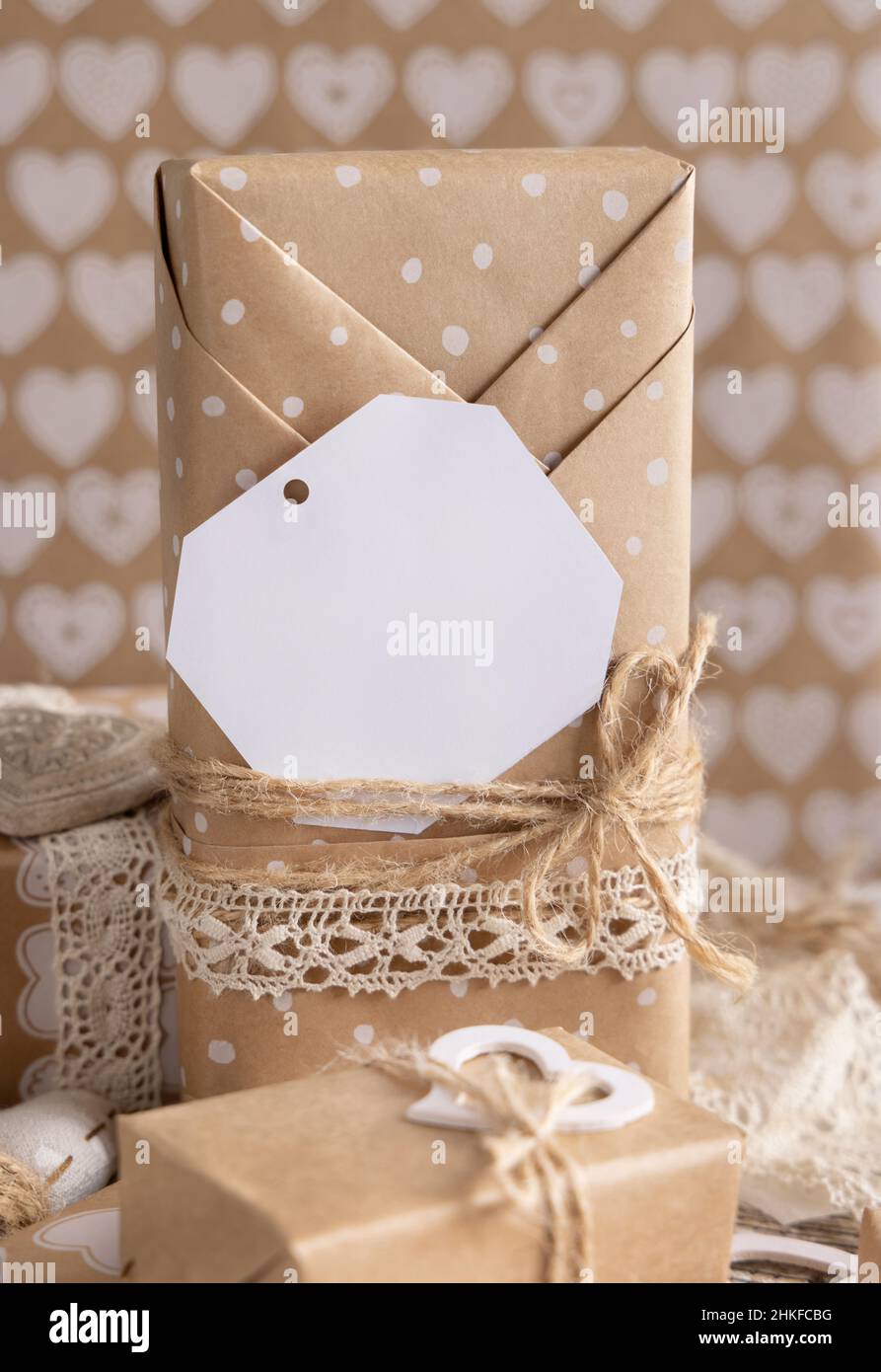 Valentines kraft paper wrapped present with gift tag and hearts close ...