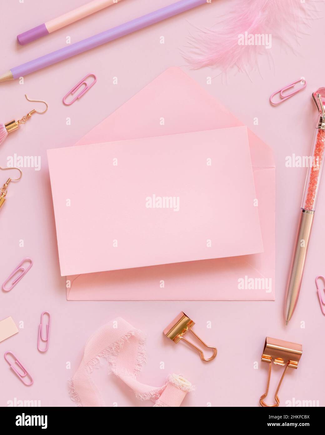 Pink paper card with envelope near school accessories and stationery on ...