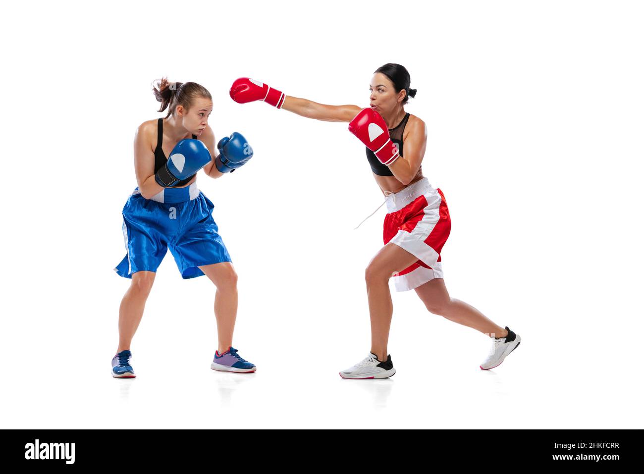 Dynamic portrait of two female professional boxers boxing isolated on ...