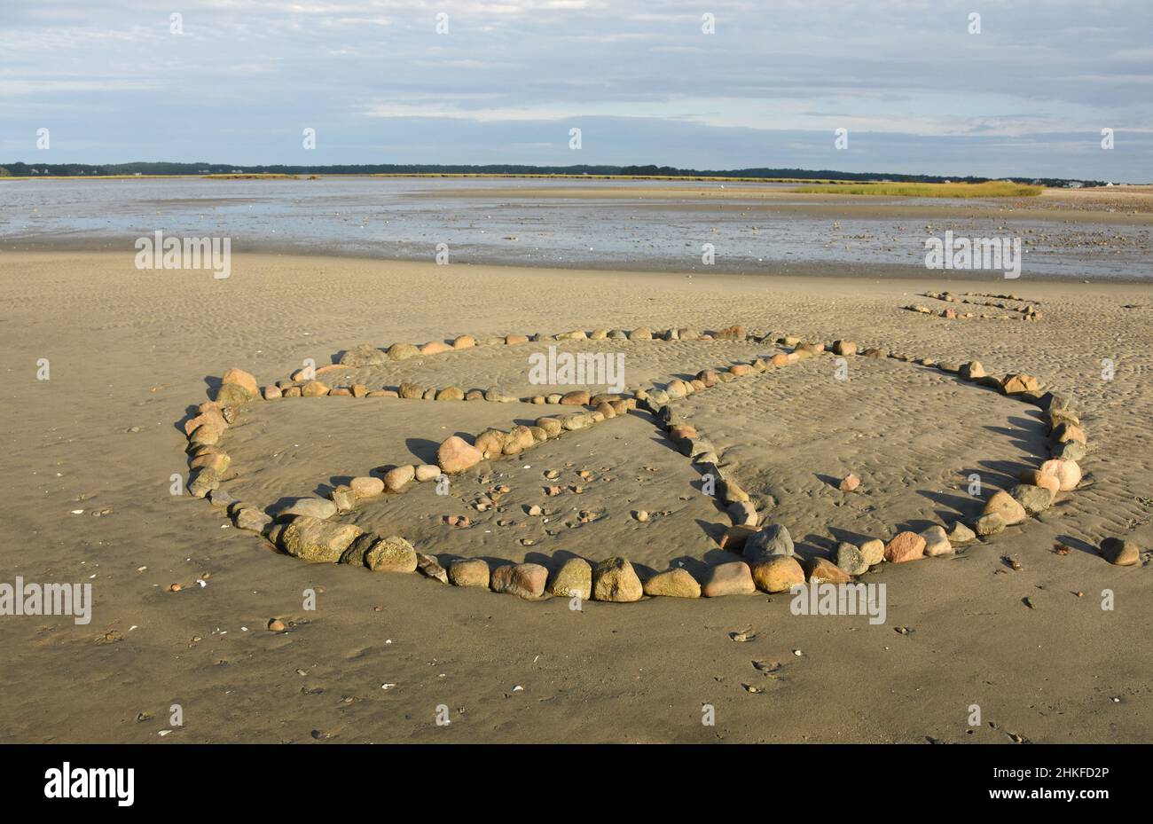 Rocks placed in a peace symbol on a sand beach Stock Photo - Alamy