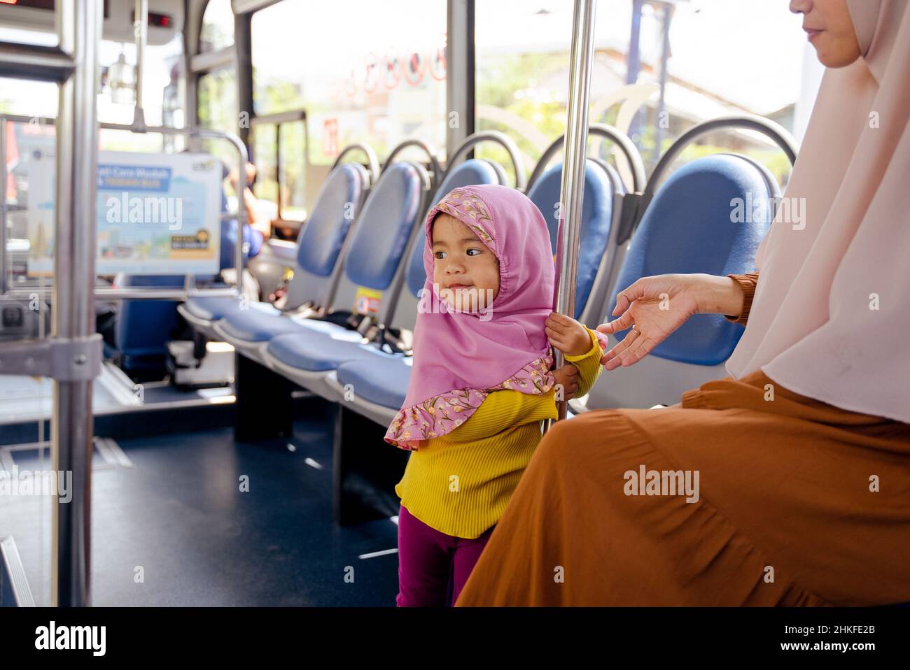 muslim little girl with hijab riding bus together with her mother Stock ...