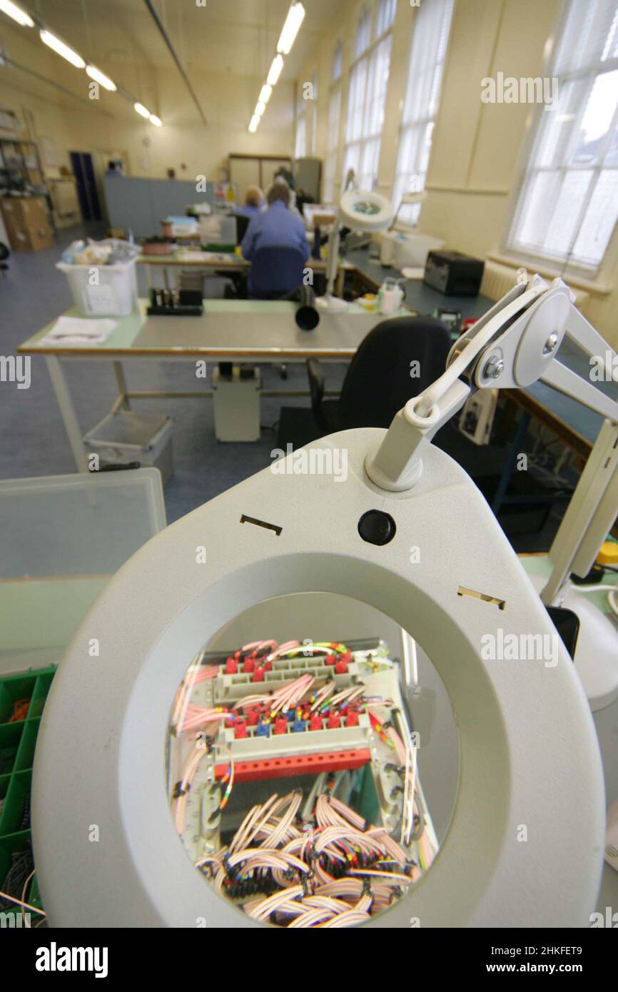 Technician in laboratory using a large illuminated magnifying glass to ...
