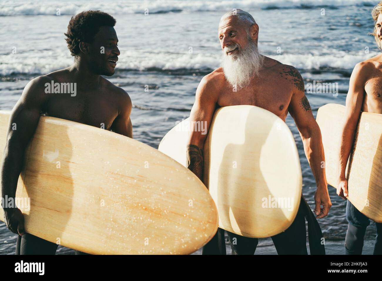 Multi generational surfer men having fun on the beach - Focus on senior ...