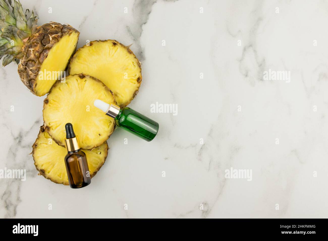 face serum with pineapple extract in cosmetic bottles on slices of ...