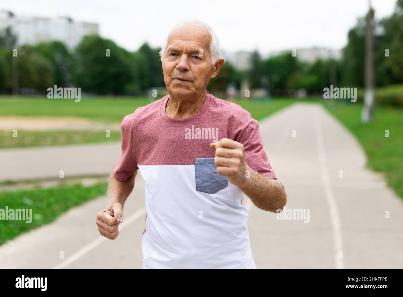 Senior man running on jogging track in nature. Healthy retirement ...