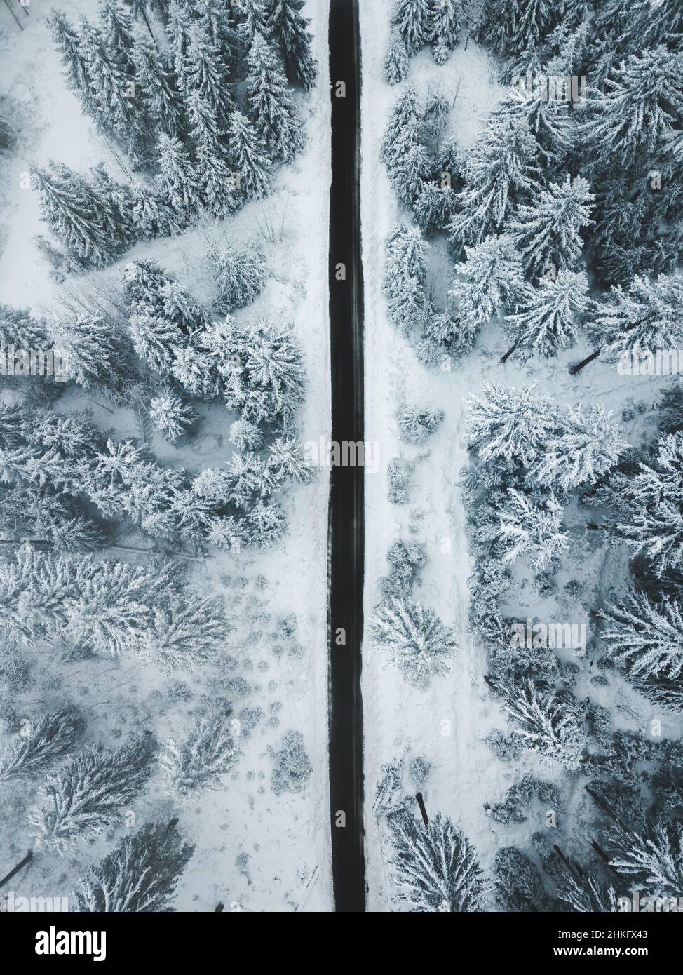 Aerial of a road going trough the snowy forest Stock Photo - Alamy