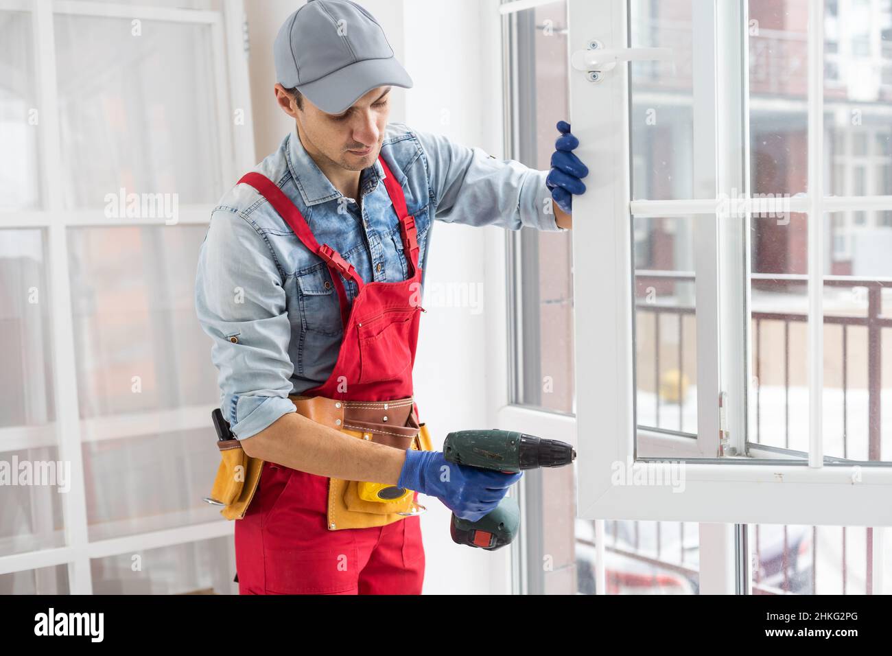 Construction worker installing window in house. Handyman fixing the ...