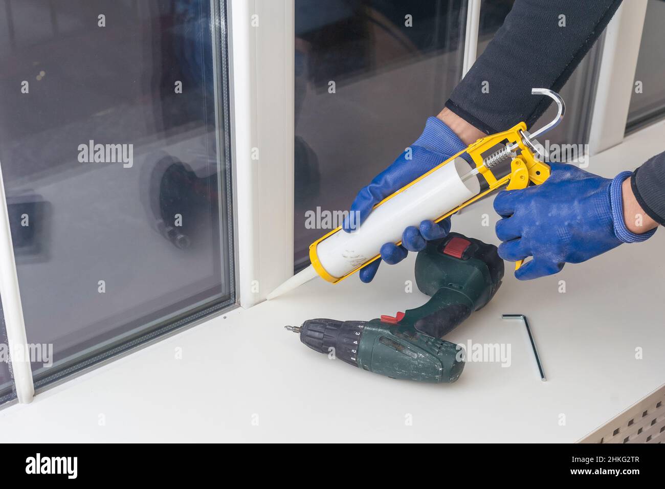 Construction worker installing window in house Stock Photo - Alamy