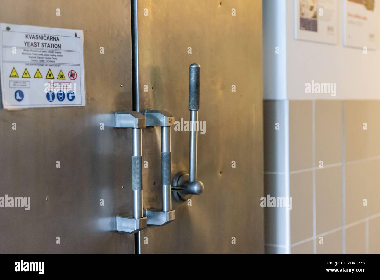 The door to a huge refrigerator at the factory. Stainless steel door to ...