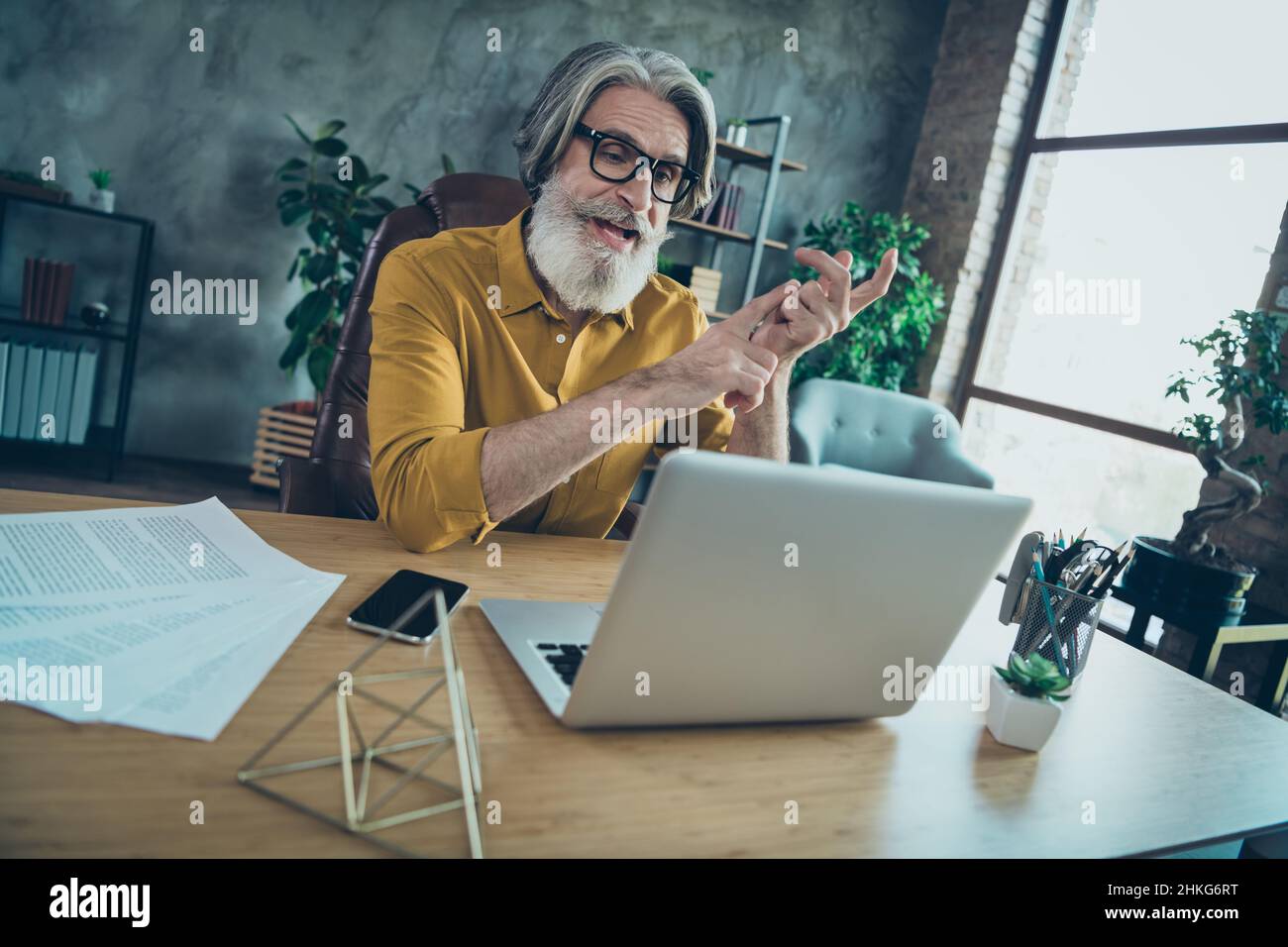 Photo of clever busy senior man wear yellow shirt glasses video chat ...