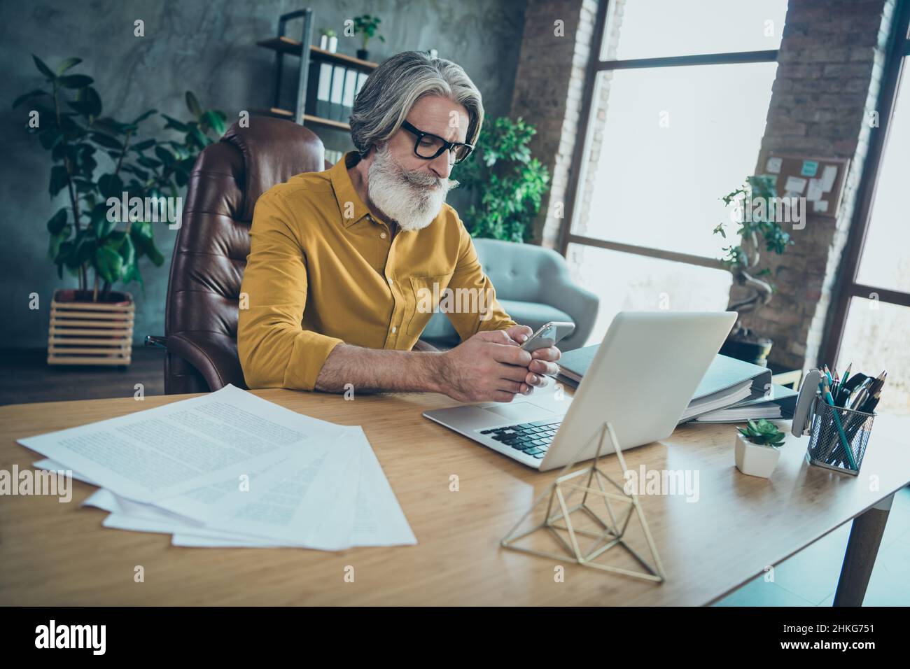 Portrait of trendy handsome focused gray-haired man bookkeeper using ...