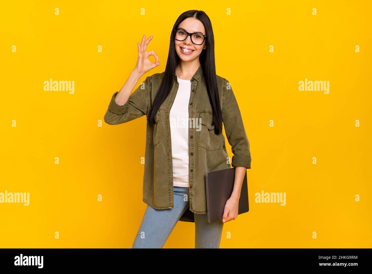 Photo of funny millennial lady hold laptop show okey wear spectacles ...