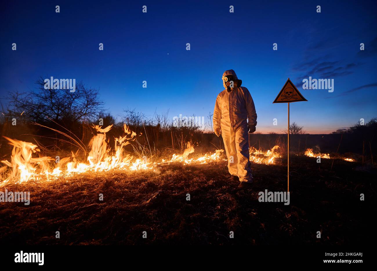 Firefighter working in field with wildfire at night. Man in suit and ...