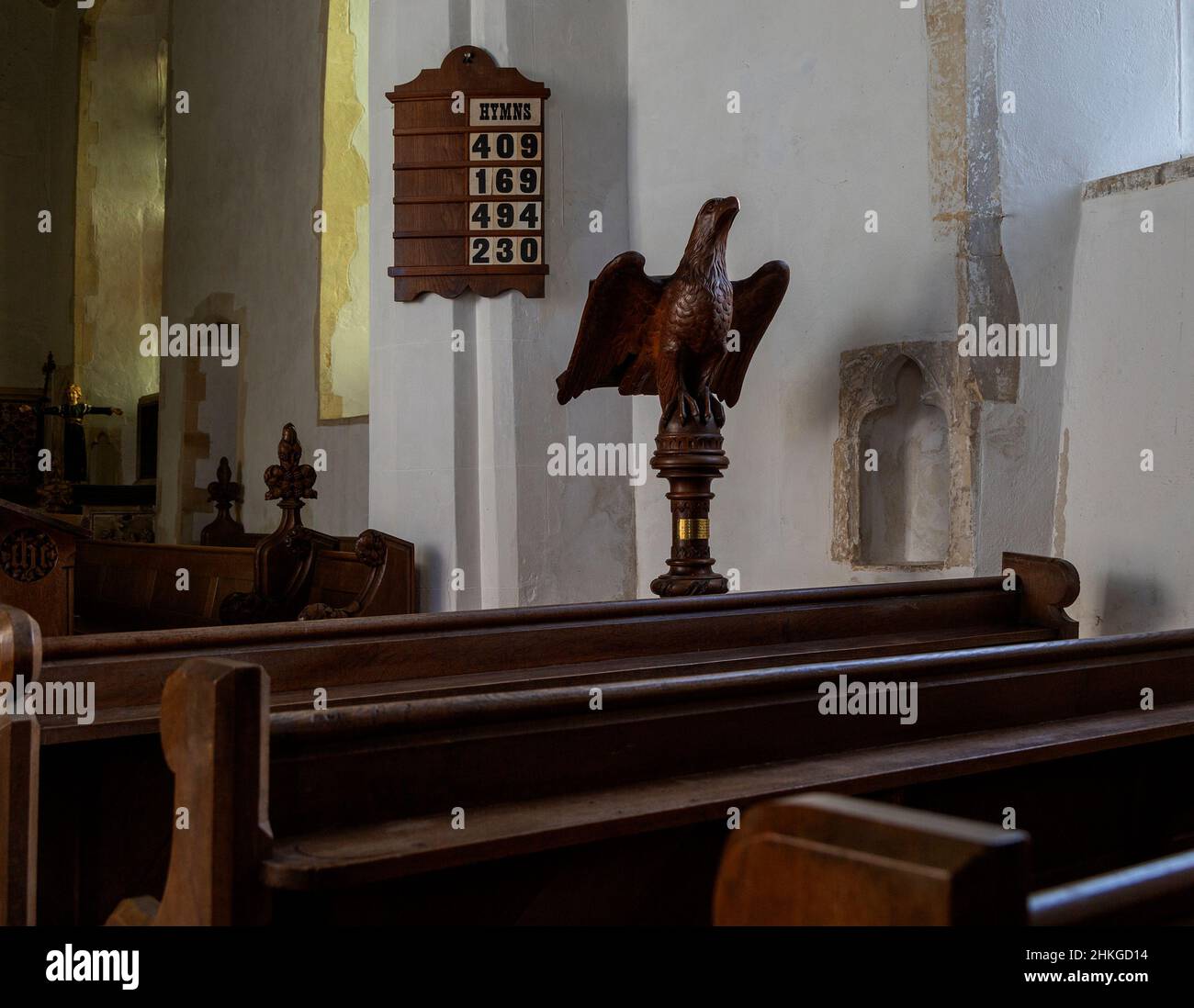 Hymn list and carved wooden eagle with pews, Oakley church, Suffolk ...