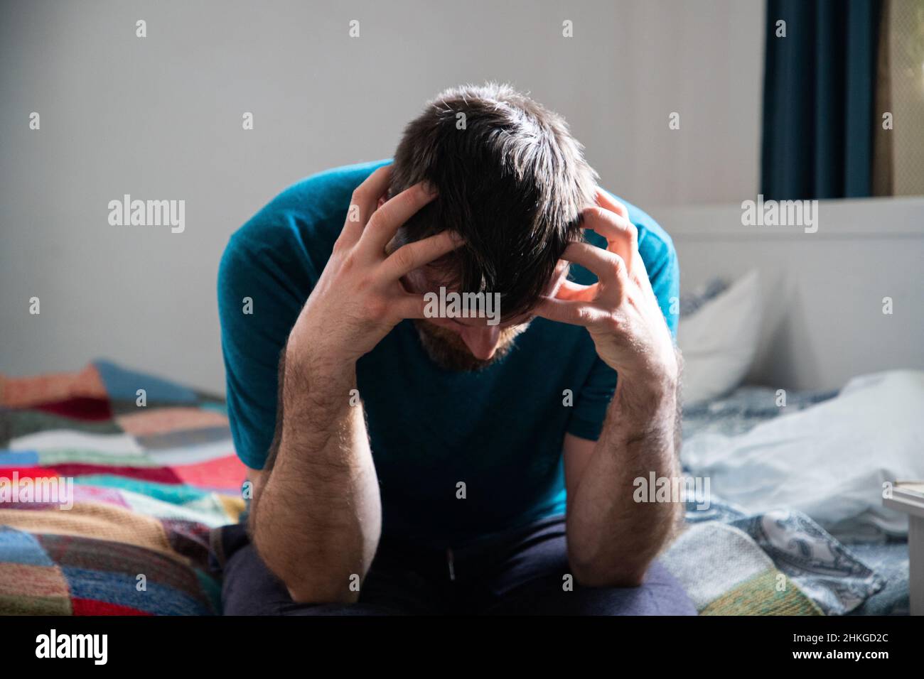 depressed man sitting on bed Stock Photo - Alamy