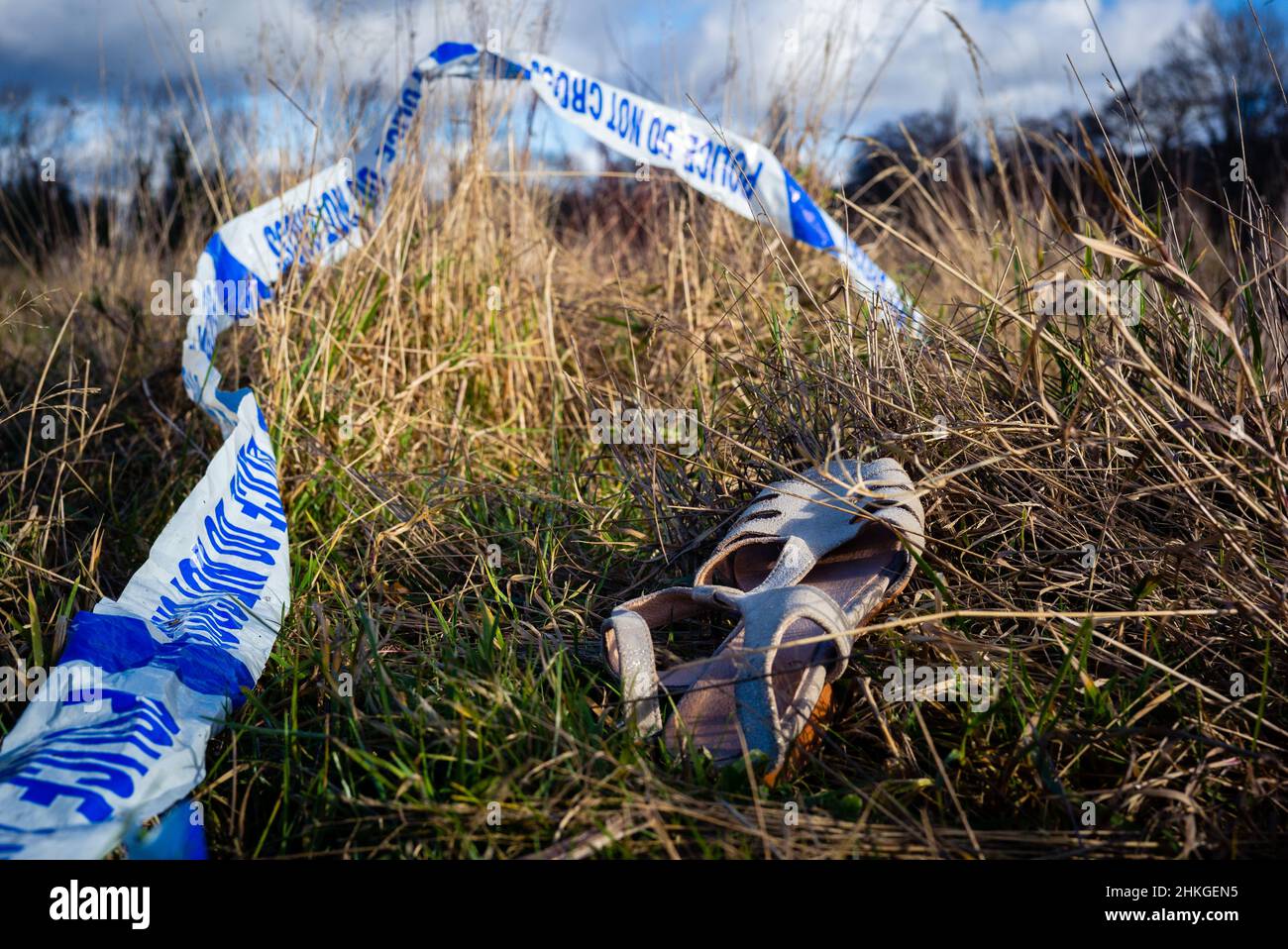 Crime scene in a meadow police tape, lost shoe Stock Photo - Alamy
