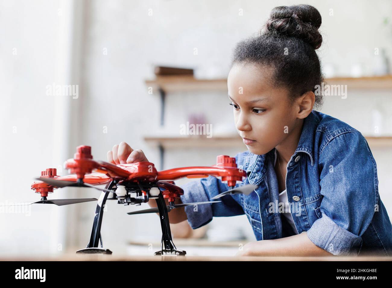 Young cute girl holding quadcopter. Child playing with drone at home ...
