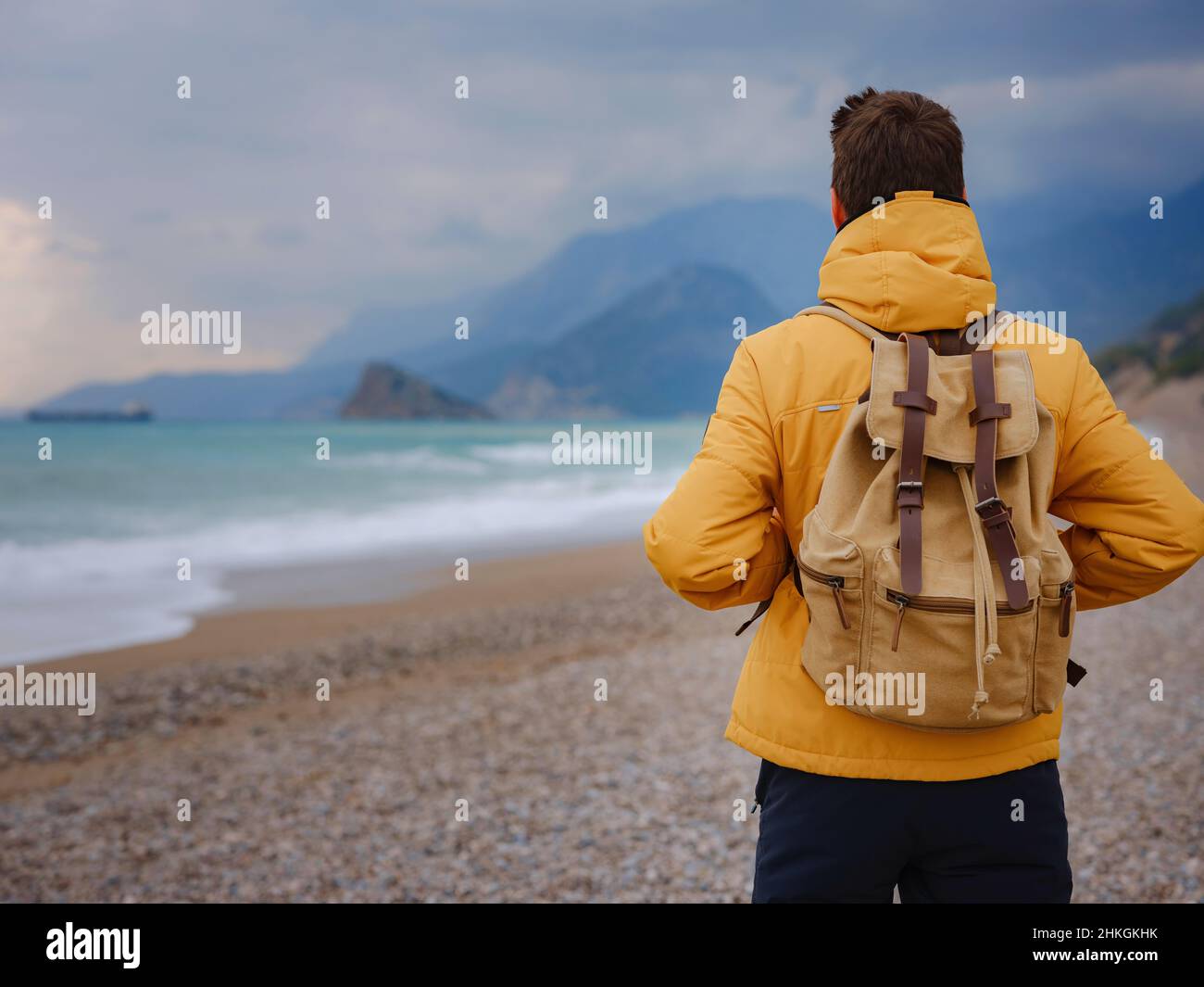 Handsome man in yellow jacket walking beach in antalya, turkey. Good ...