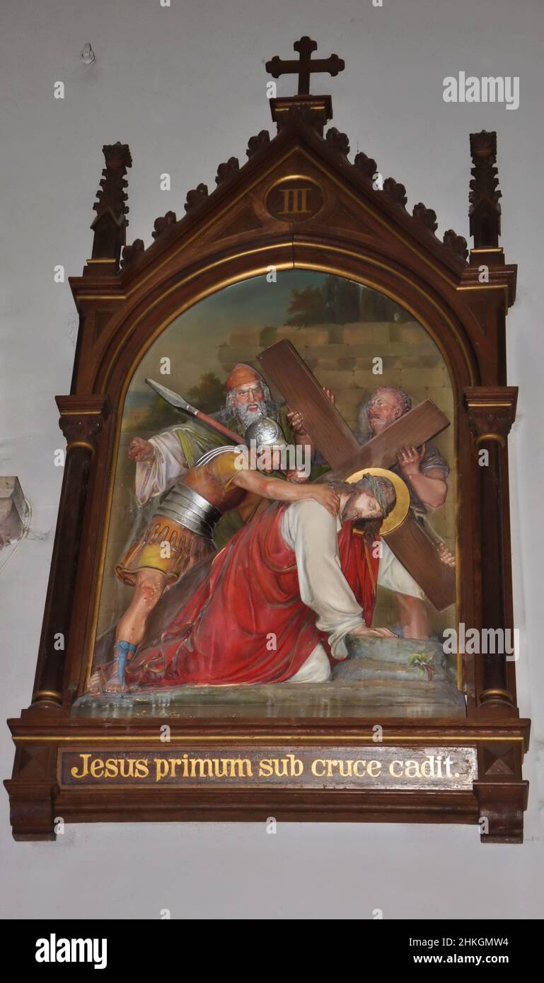 A religious depiction of Jesus falling carrying a cross on his back in ...