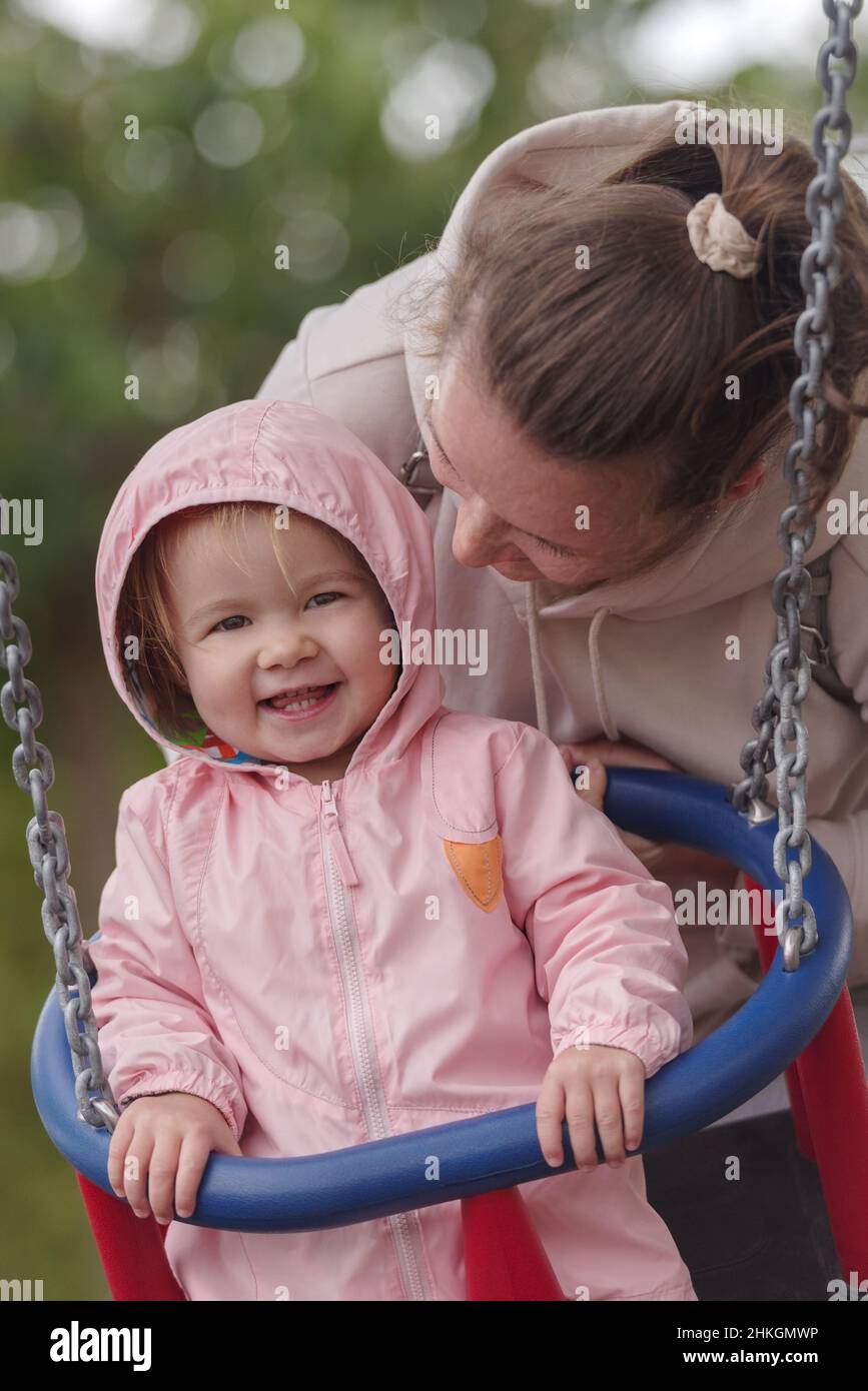 Mother pushing daughter swing hi-res stock photography and images - Alamy