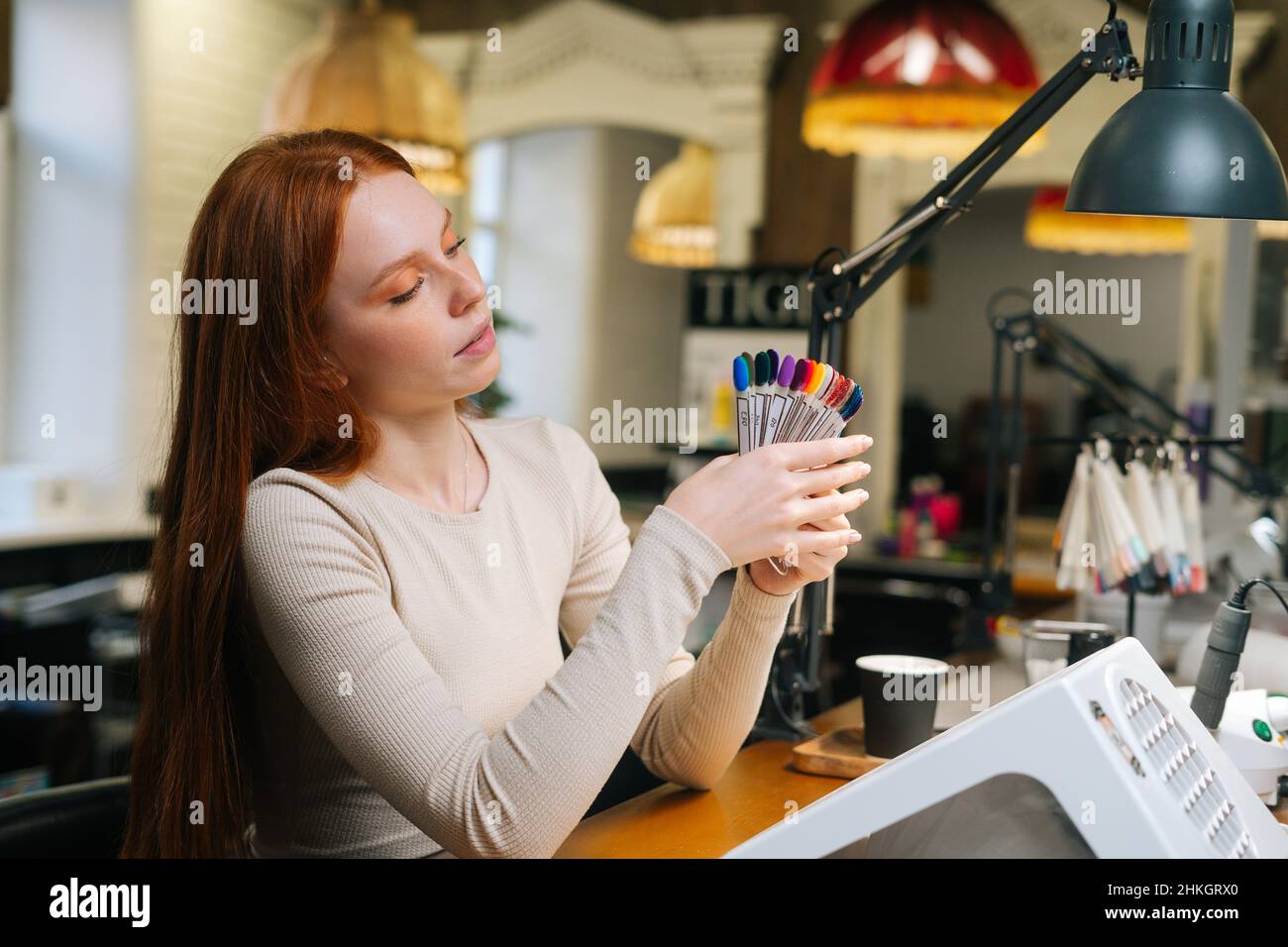 Side view of focused pretty young woman client choosing colour from ...