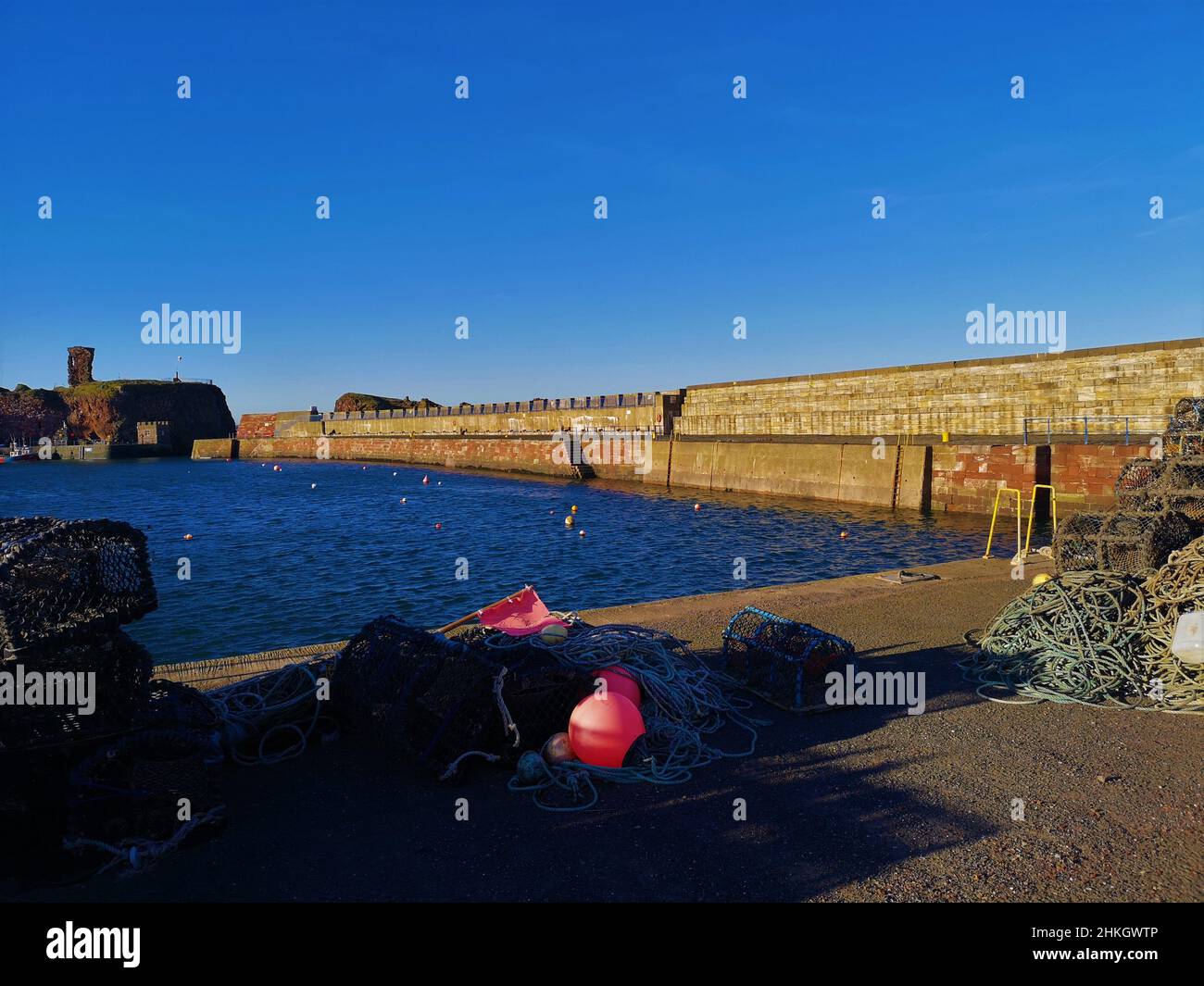 A view of the rocky coastline and harbour in the historic East Lothian ...