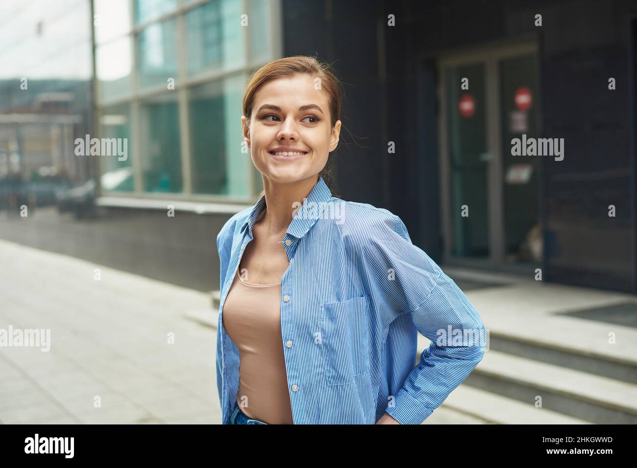 Happy confident business woman walking out of modern office center ...