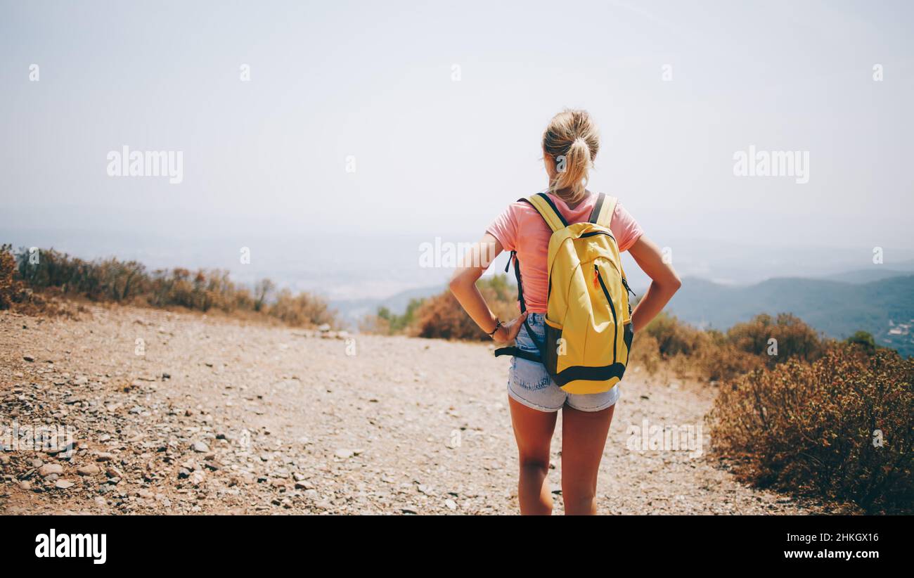 Traveling woman walking with backpack on road Stock Photo - Alamy