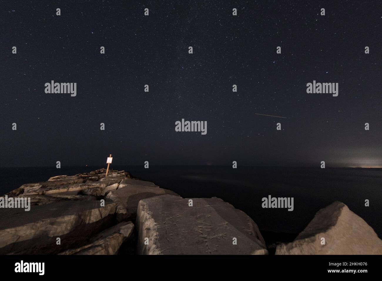 Sea with starry night sky seen from the cliff Stock Photo - Alamy