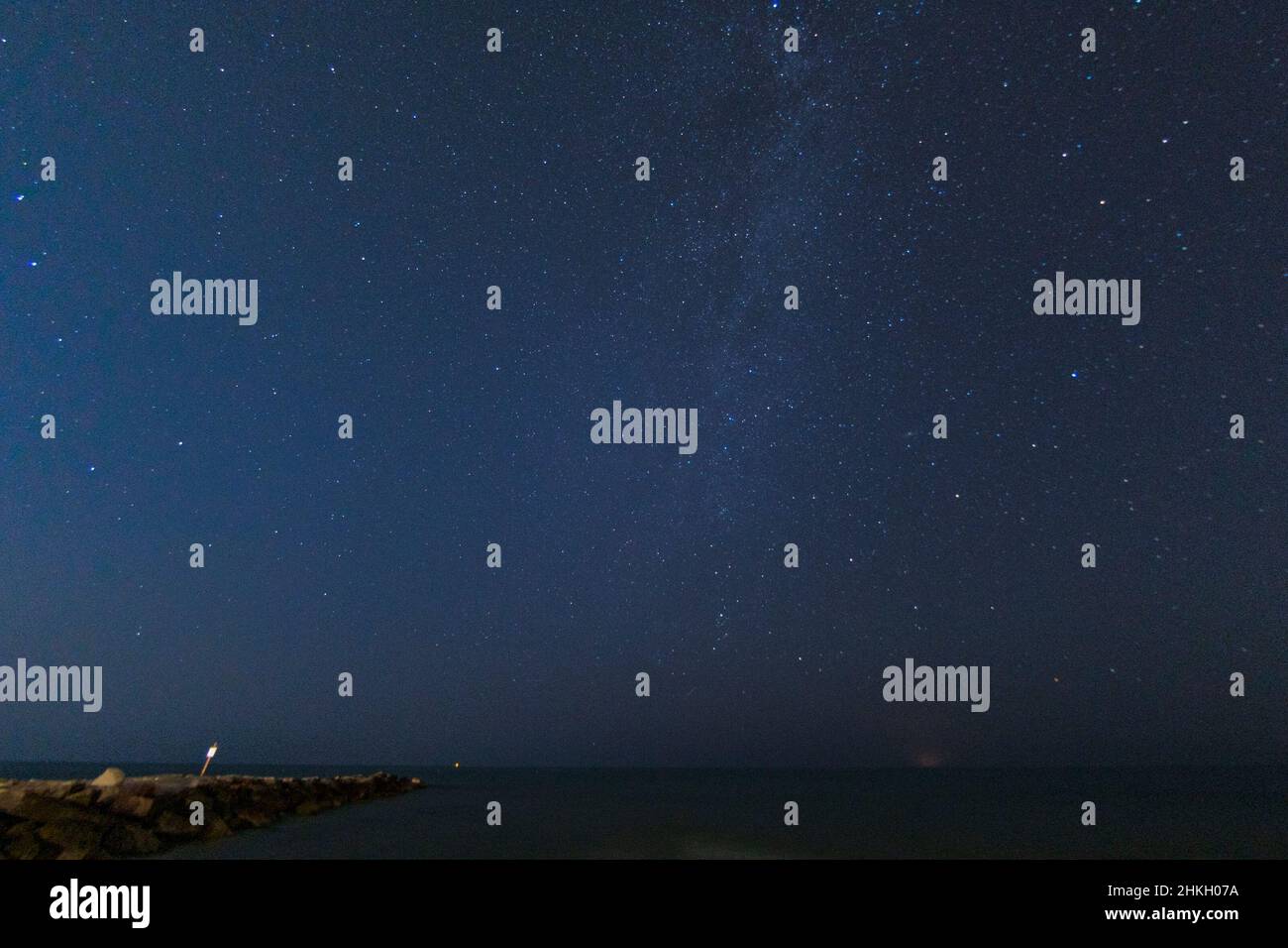 Sea with starry night sky seen from the cliff Stock Photo - Alamy