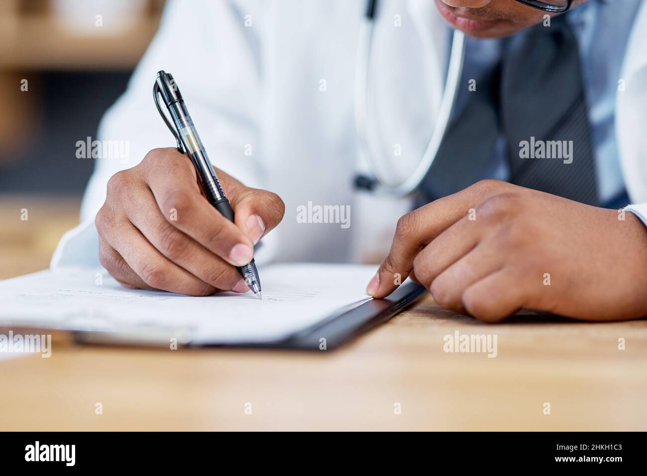 Updating his notes. Closeup shot of an unrecognisable doctor writing ...