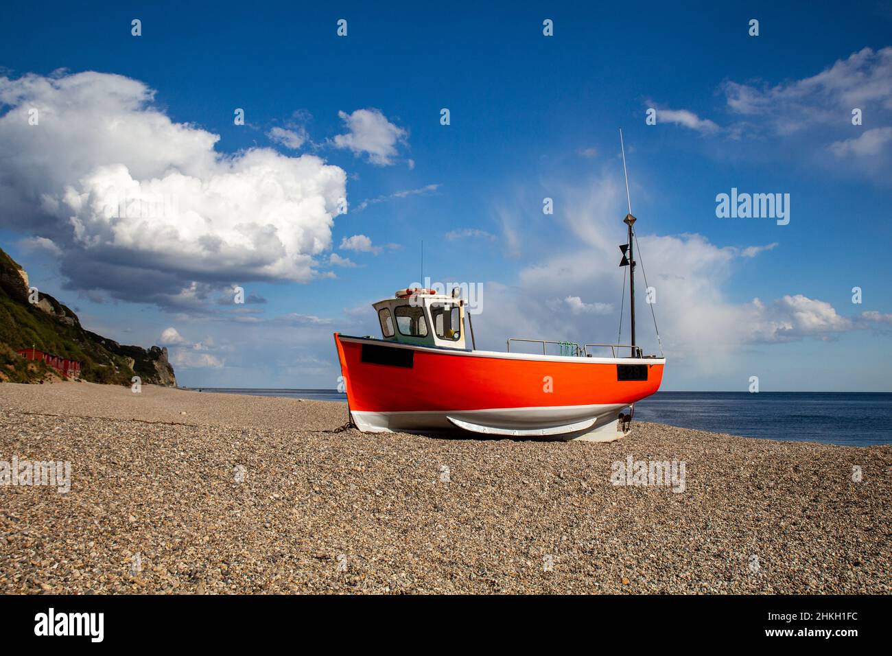 Single red small fishing boat on shingle beach. E293 red fishing boat ...