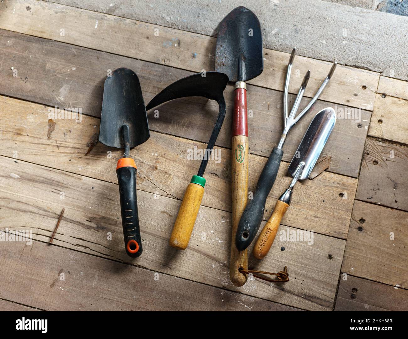 Hand garden tools for working in small spaces sit on a rough wooden ...