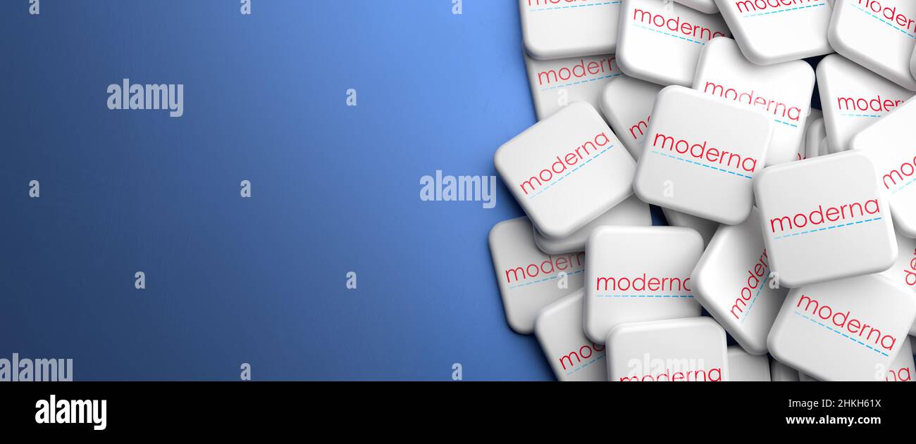 Logos of the pharmaceutical company Moderna on a heap on a table. Copy ...