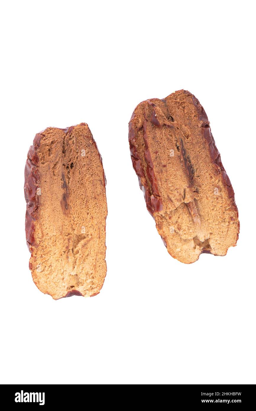 Dried dates cut into two halves on a white background. Top view of date ...