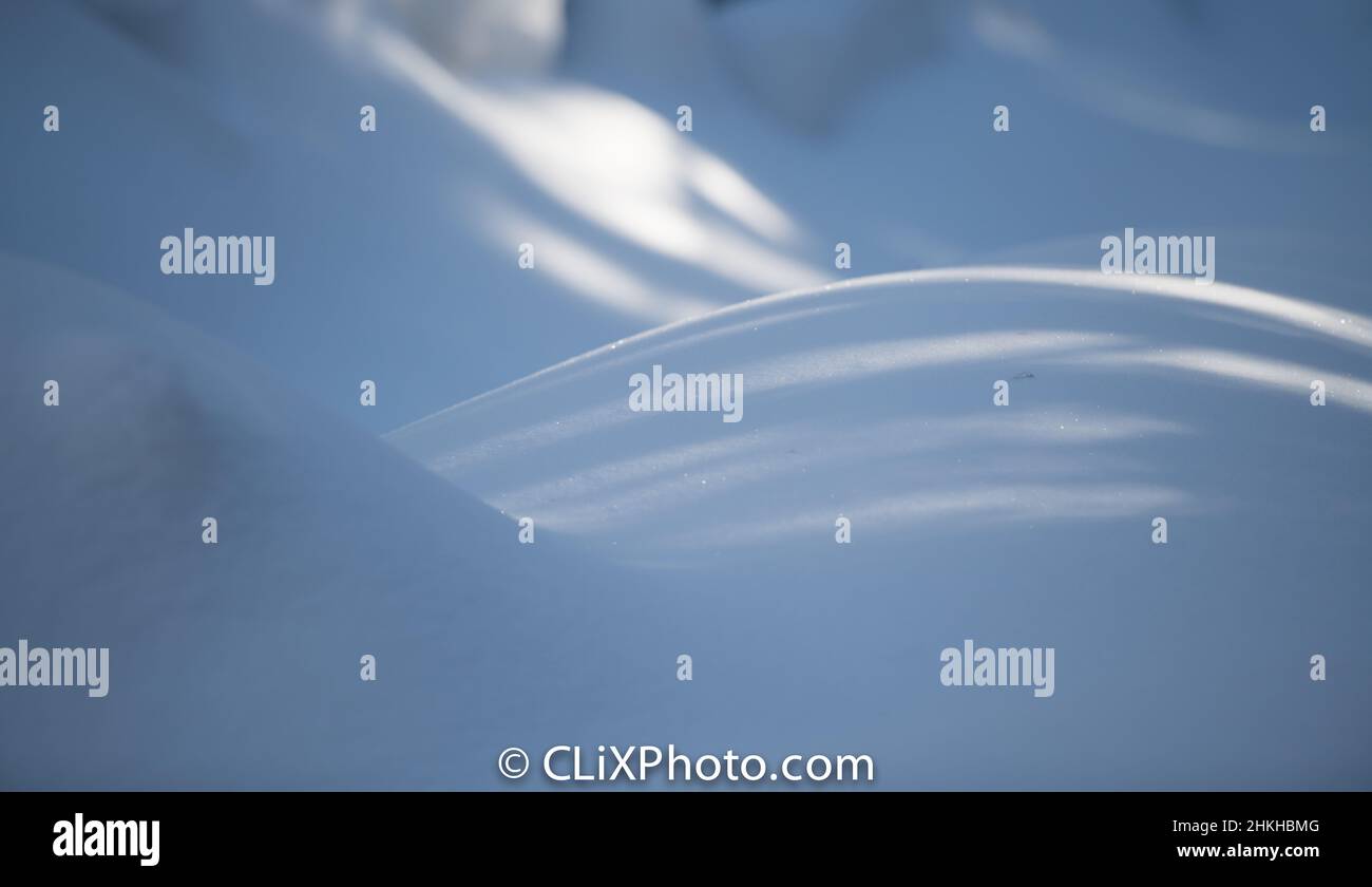 shadows cast on fresh snow on snow mounds or hills of snow curved lines ...