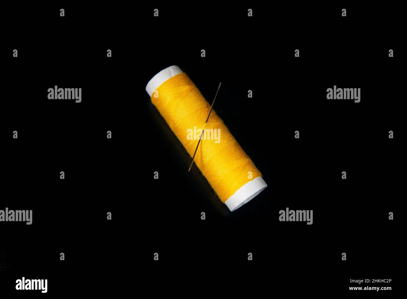 yellow sewing thread on black background for designers Stock Photo - Alamy