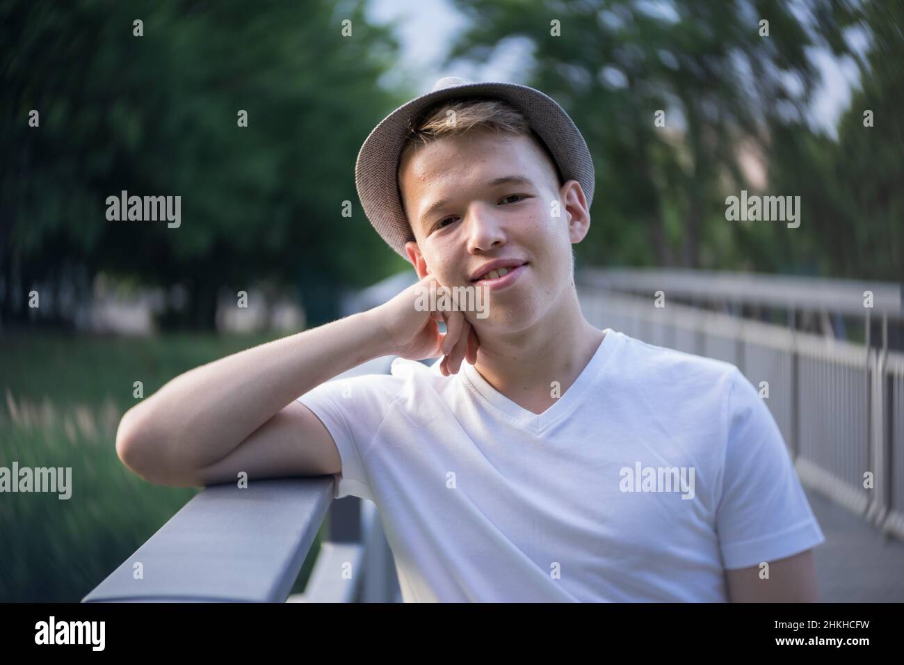 Portrait of a teenager standing on a bridge. Natural skin of the face ...