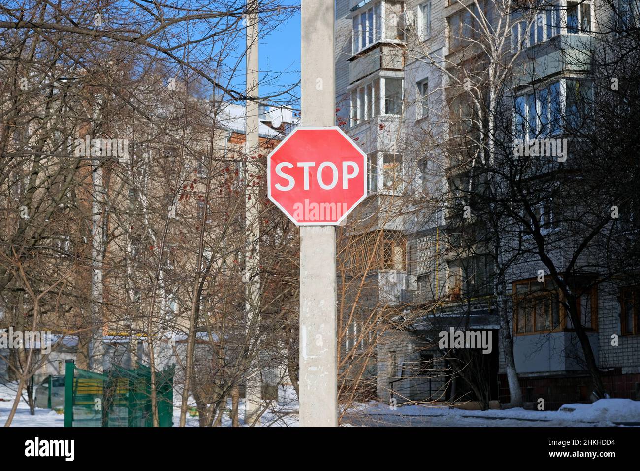 A red stop sign on a pole in the courtyard of a residential complex ...