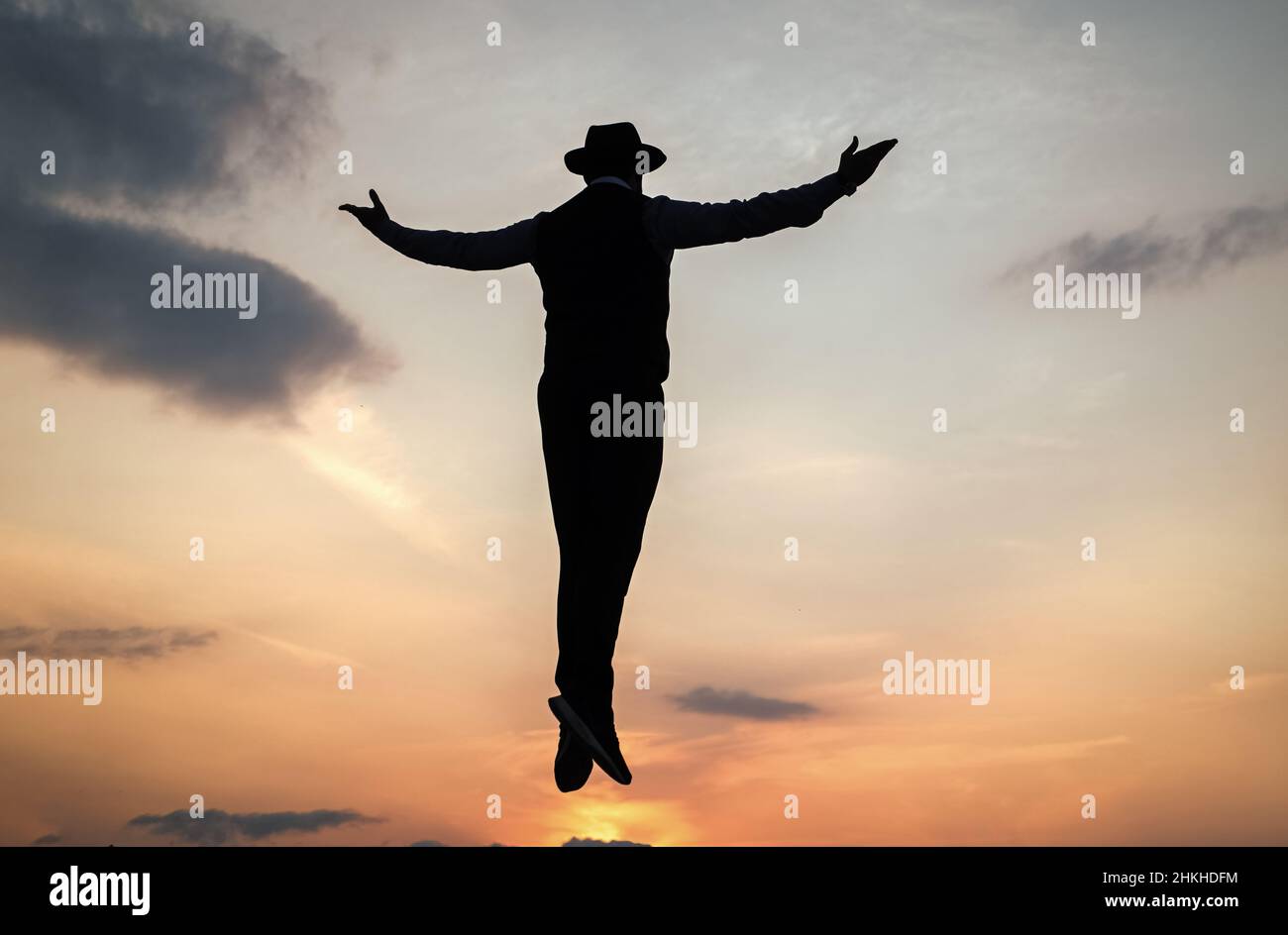 silhouette of man float in sunrise sky with raised hands, freedom Stock ...